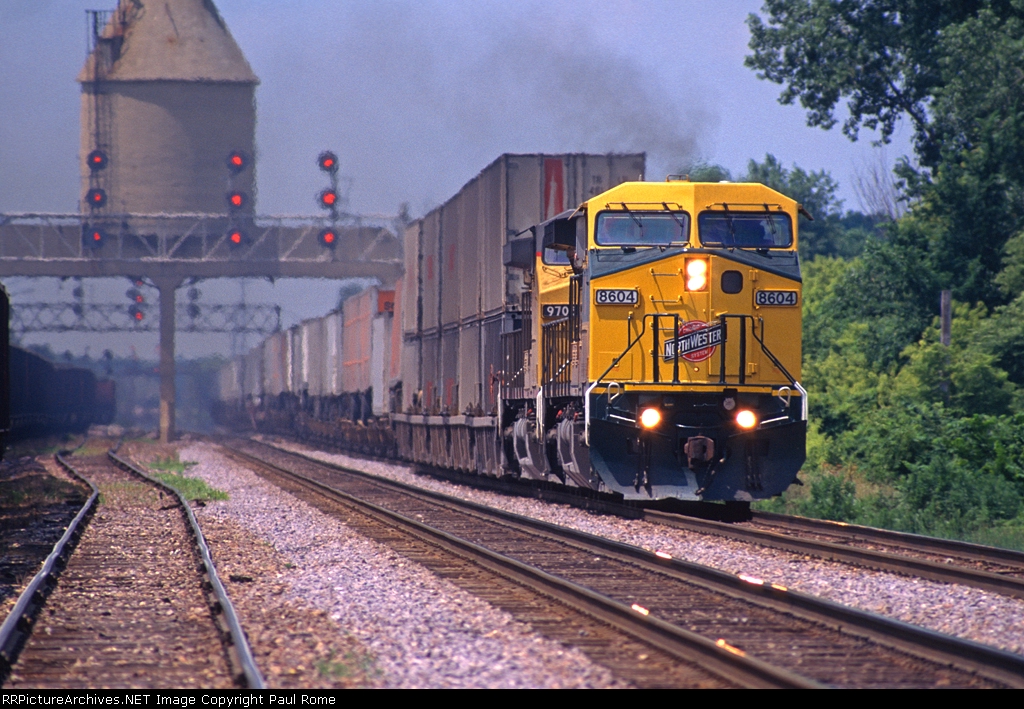 C&NW 8604 - UP 9705, GE C44-9W, lead an eastbound under the massive steam era coaling tower